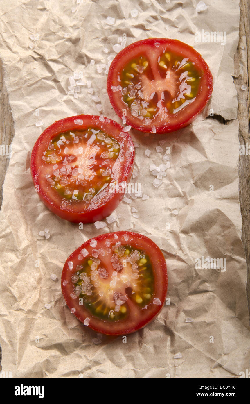 tomato slices on brown paper with rough sea salt Stock Photo - Alamy