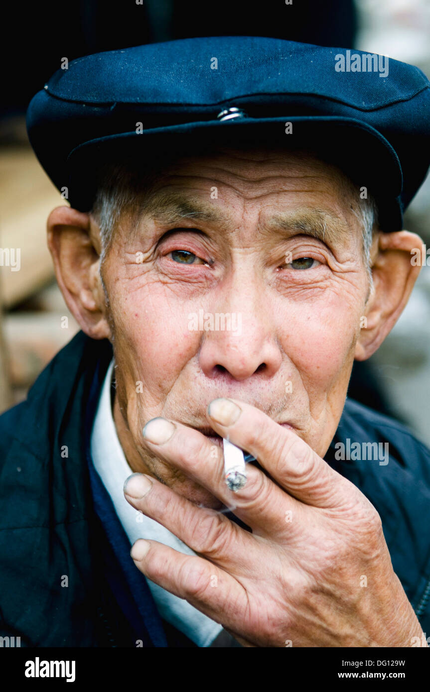 A Chinese man enjoys his cigarette Stock Photo - Alamy
