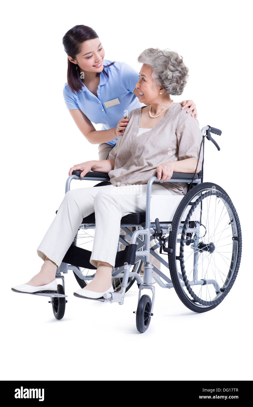 Female nursing assistant taking care of senior in wheelchair Stock ...