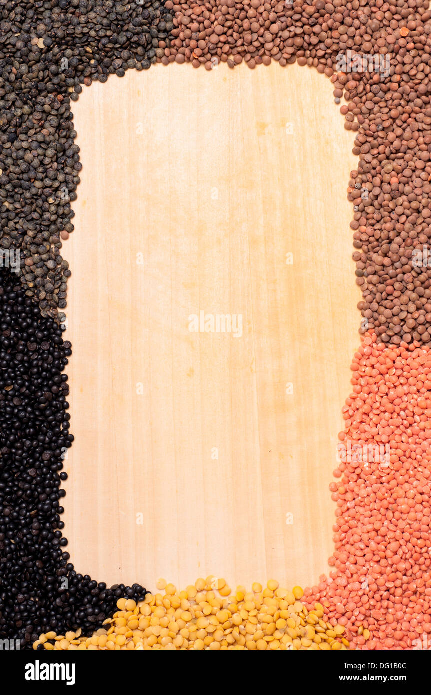 Frame of yellow, red, brown and black lentils on a wooden board Stock ...