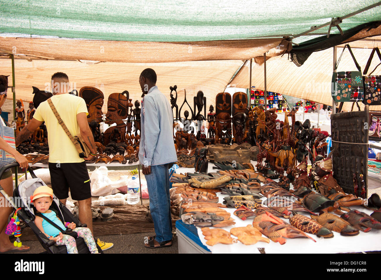 Outdoor market stall selling African goods and wood carvings ...