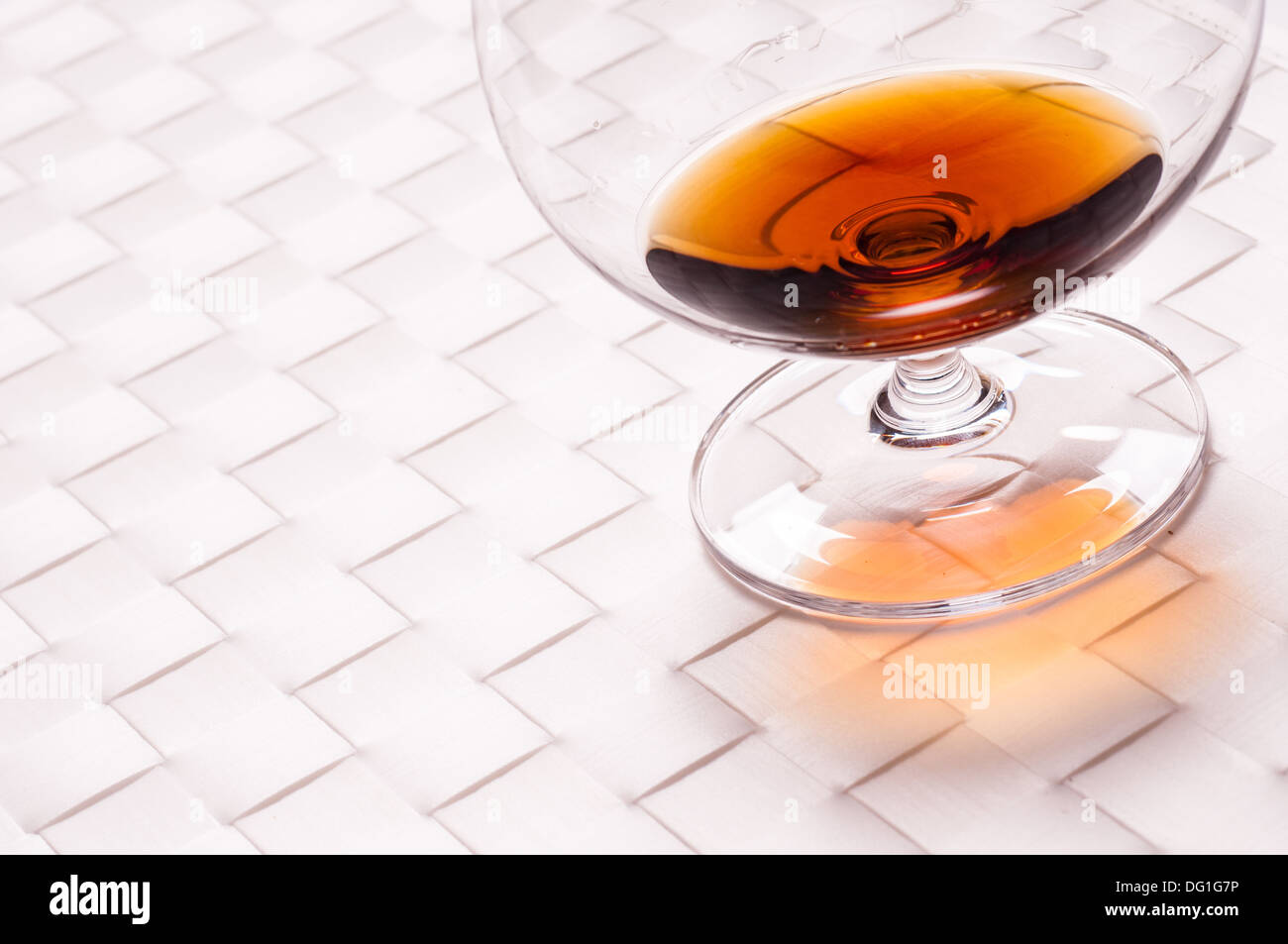 Old amber brandy in a glass on a white background Stock Photo - Alamy