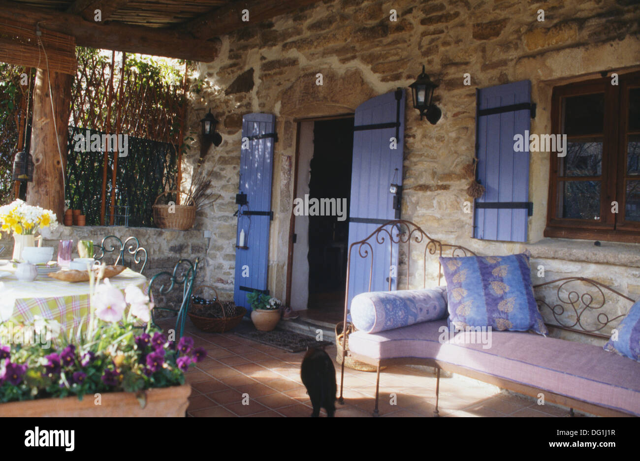 Blue shutters on doors and windows looking onto veranda with pink ...