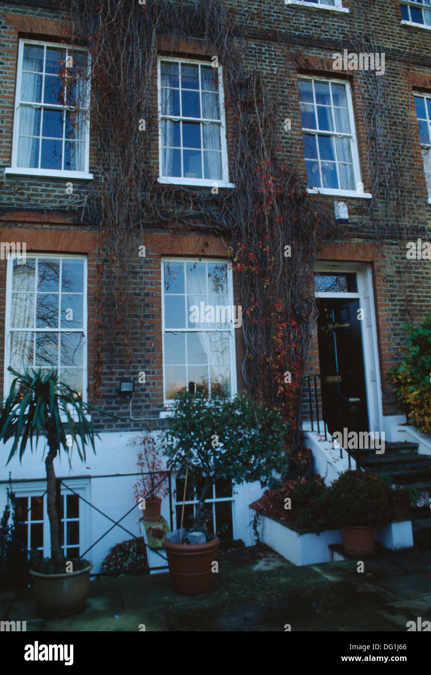 Large Georgian townhouse with steps down to paved area with small trees ...