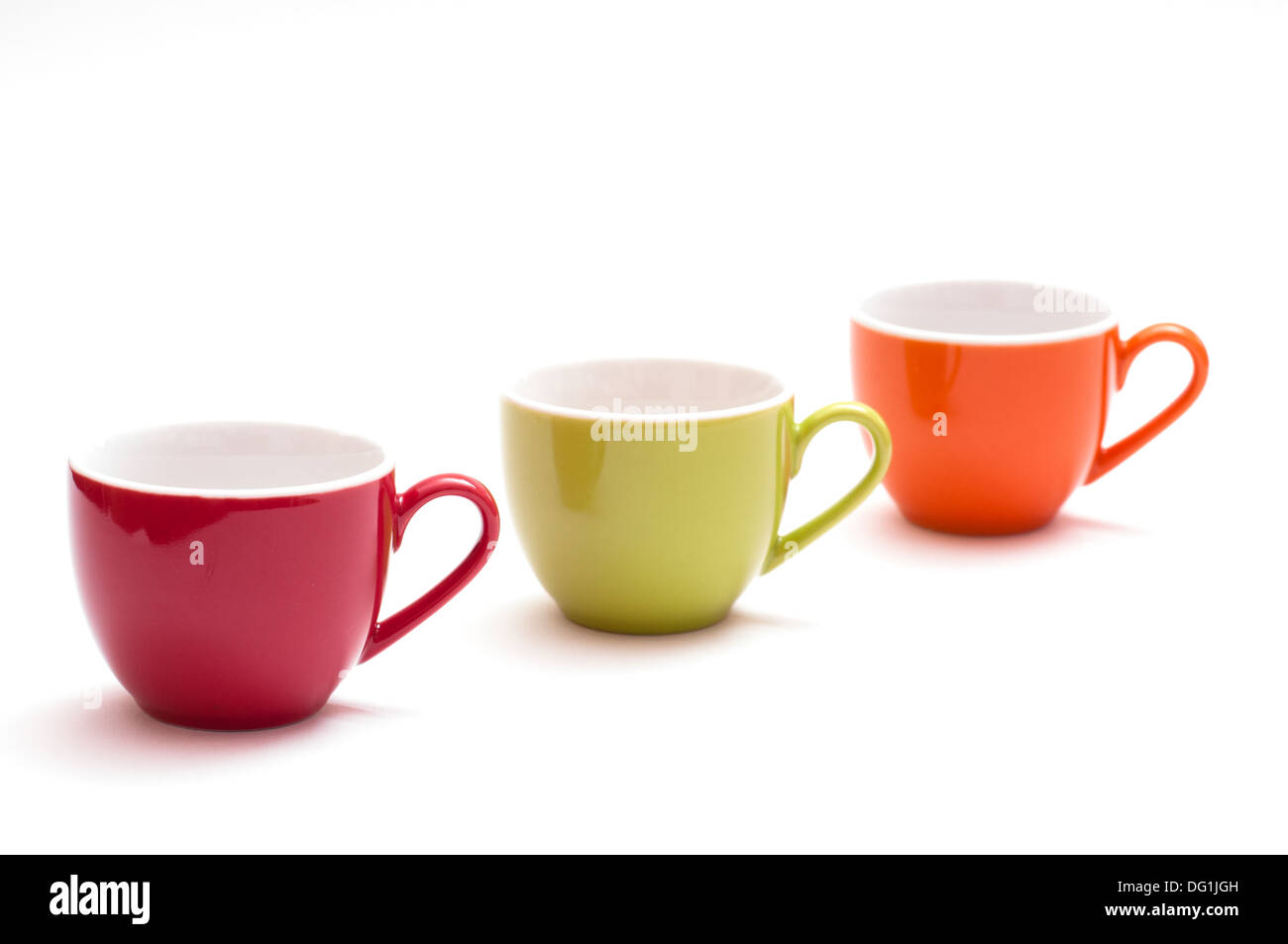 Three coloured cups on a white background Stock Photo - Alamy