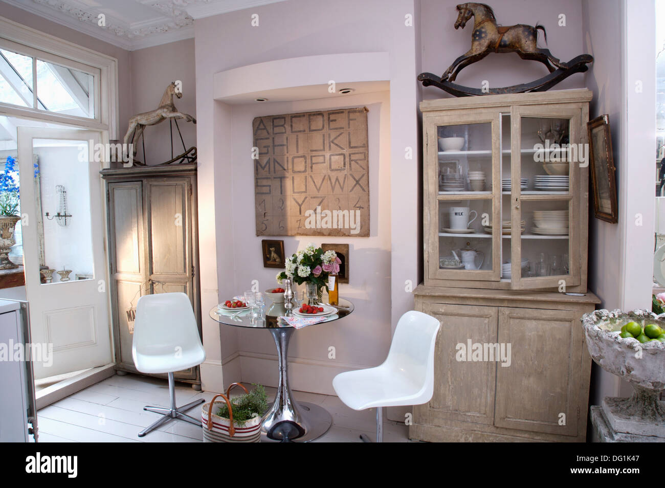 White polypropylene chairs and chrome pedestal table in front of alcove ...