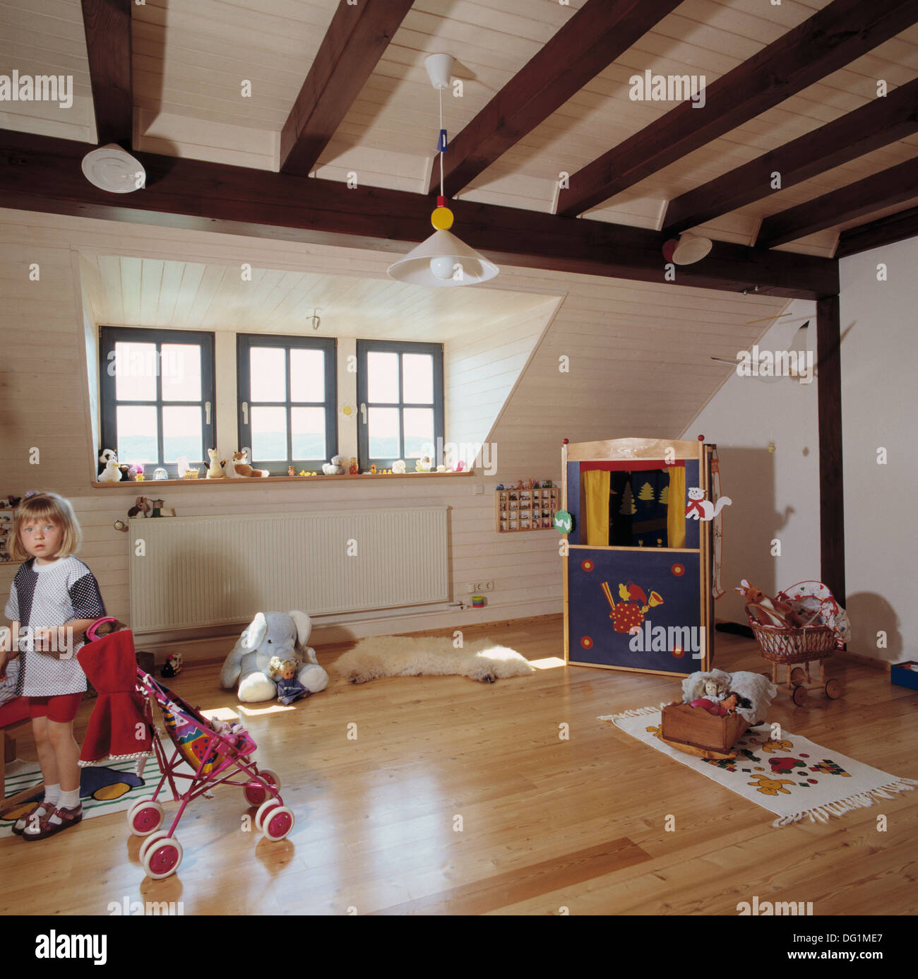 Small girl in playroom with wooden flooring and puppet theater Stock ...