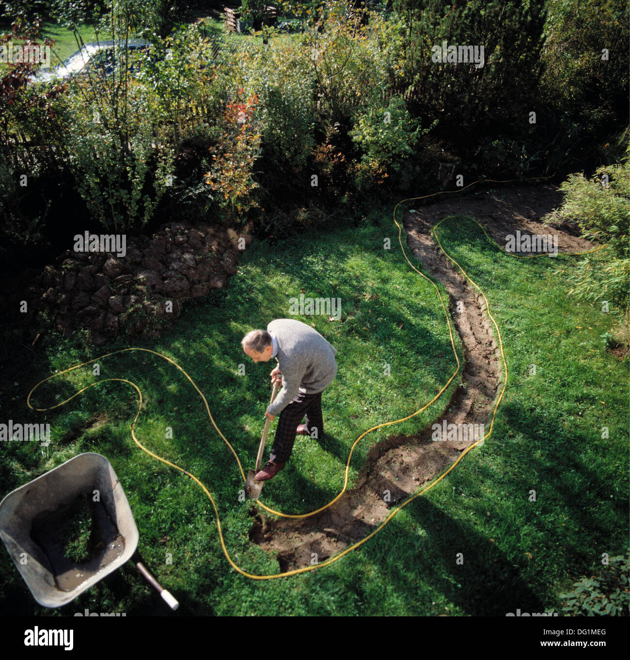 Birds-eye view of man digging out a new curved path in lawn Stock Photo ...