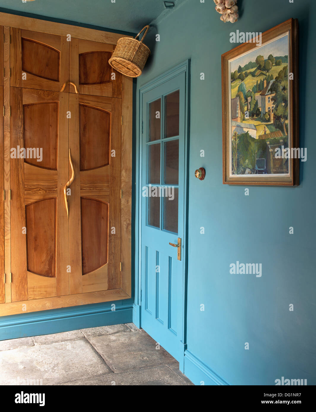 Hand-crafted pale wood cupboard door in turquoise country hall with ...