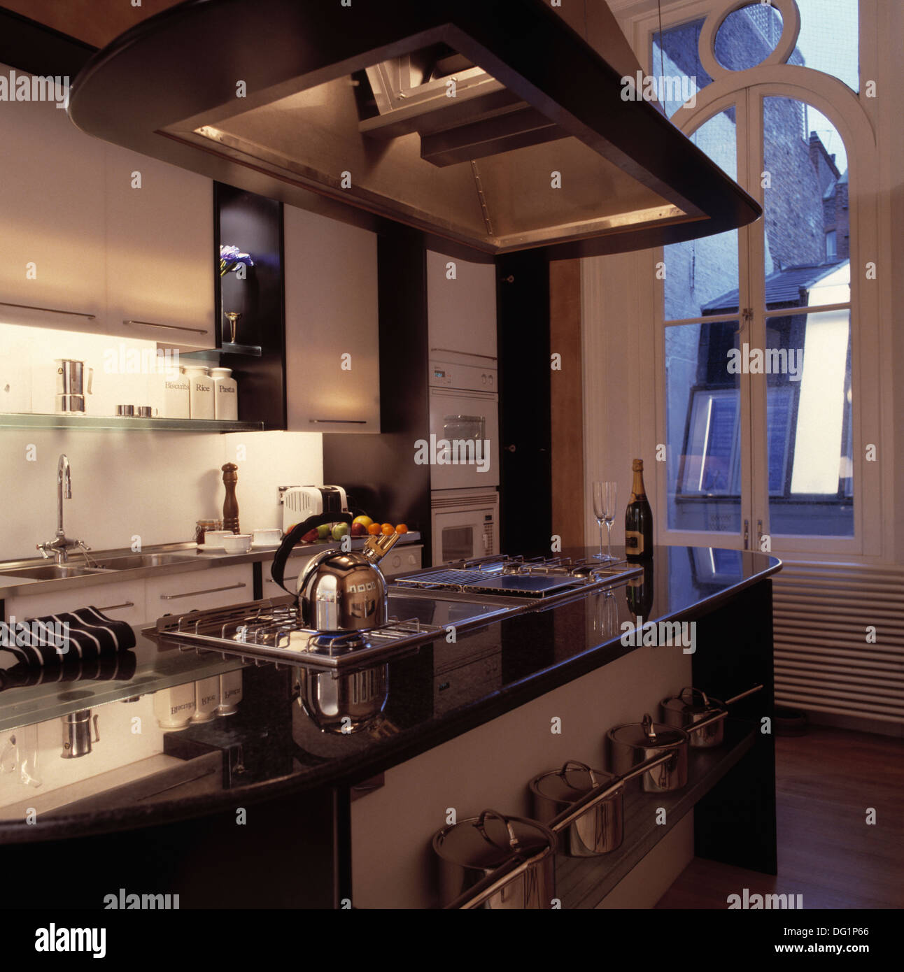 Large extractor above island unit with Alessi kettle on hob in modern ...