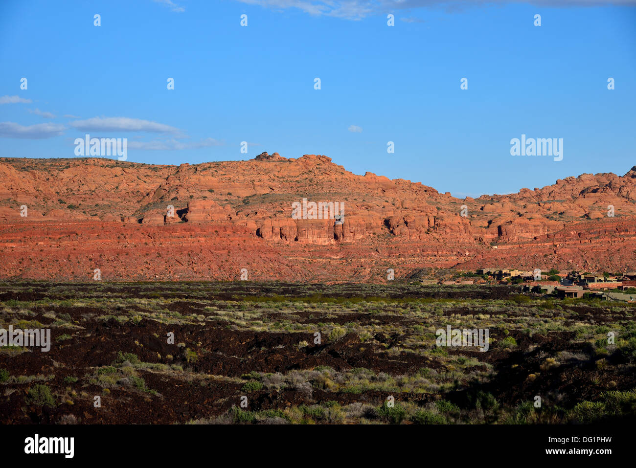 Red sandstone cliff and dark volcanic lava flow. Southern Utah, USA ...
