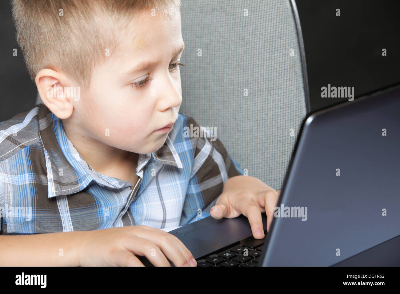 Computer addiction child boy with laptop notebook black background ...