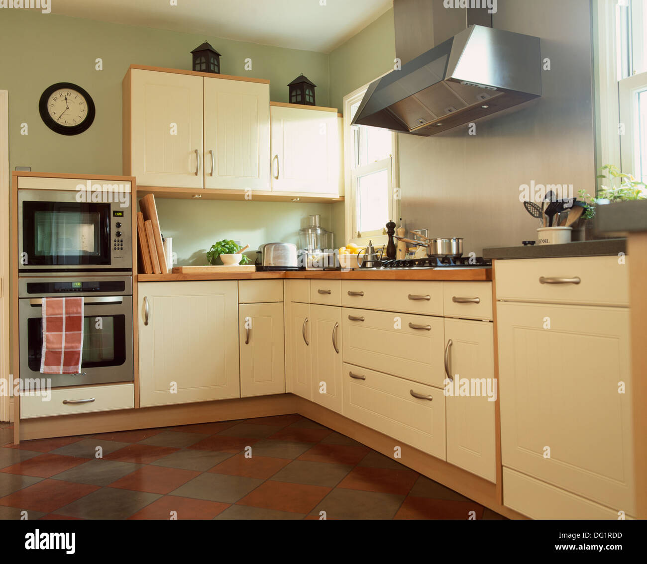 Stainless steel double oven and extractor in pale green modern kitchen ...