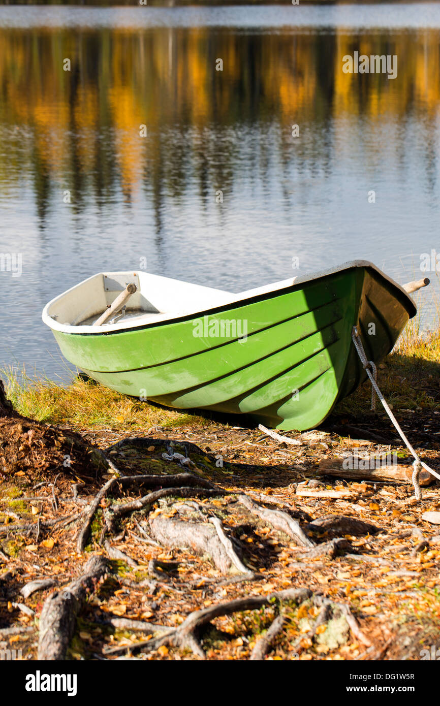 Boat at rough by tree roots lake shore Stock Photo - Alamy