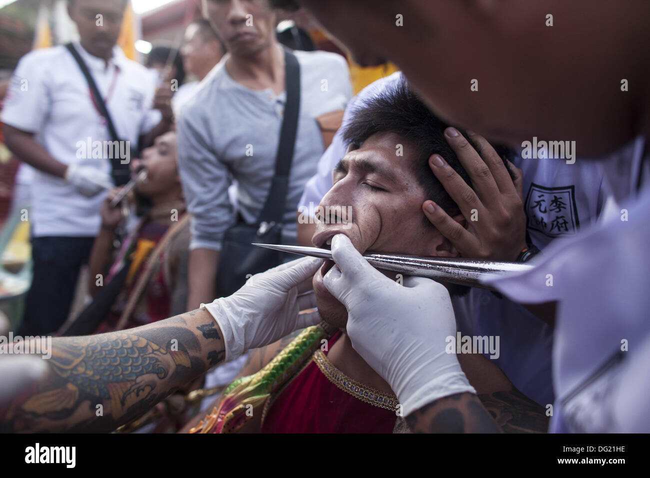 Phuket, Thailand. 12th Oct, 2013. A devotees has his face pierced with ...