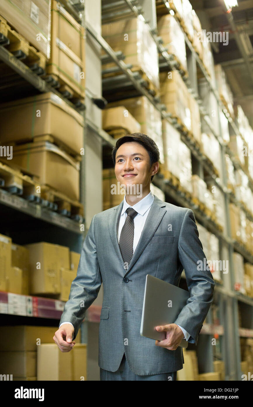 Happy businessman on the move in warehouse Stock Photo - Alamy
