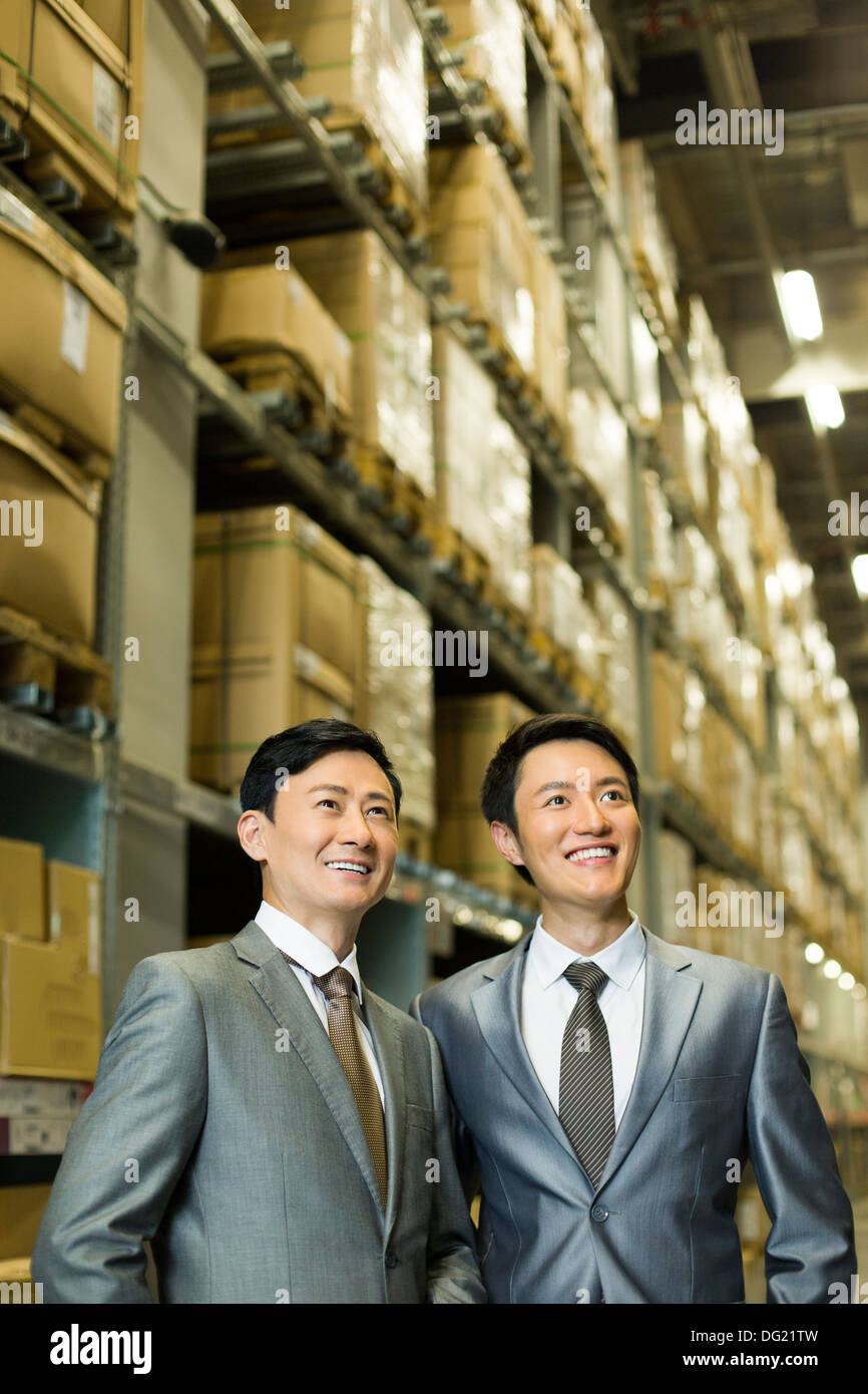 Happy businessmen in warehouse Stock Photo - Alamy