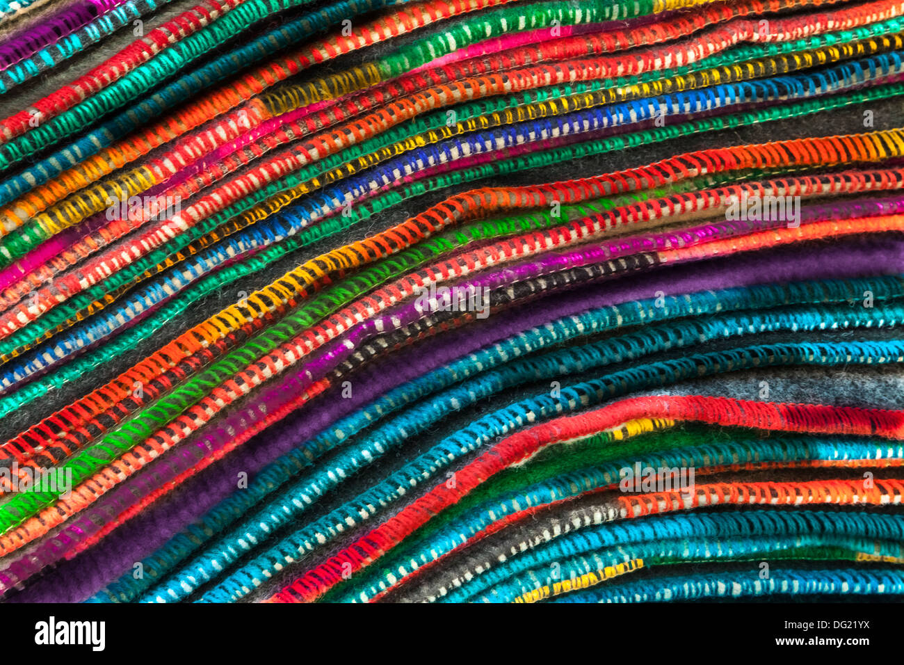 India, Rajasthan, Jaipur, stack of mats with colorfully embroidered ...