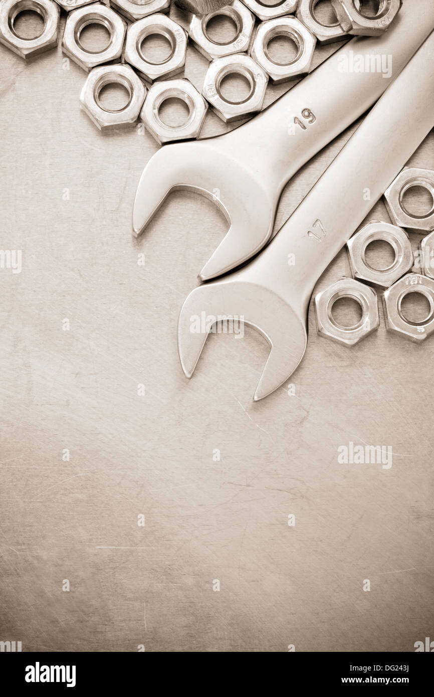 wrench and nut tool on metal background texture Stock Photo - Alamy