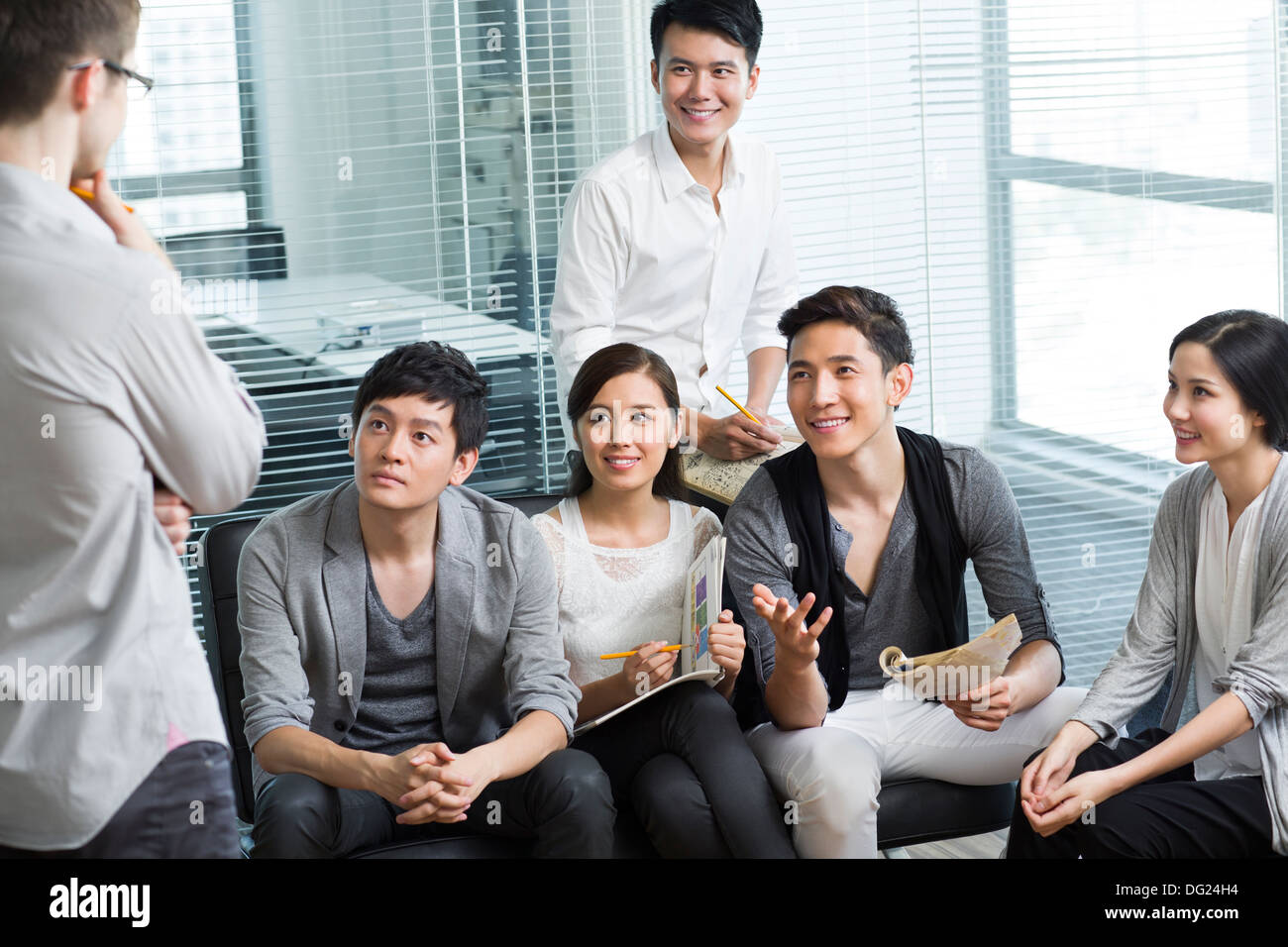 Young office workers holding a meeting Stock Photo - Alamy
