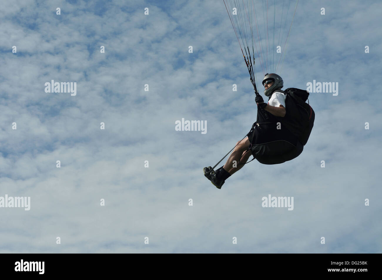 Pilot sitting in paraglider seat high in the sky Stock Photo - Alamy
