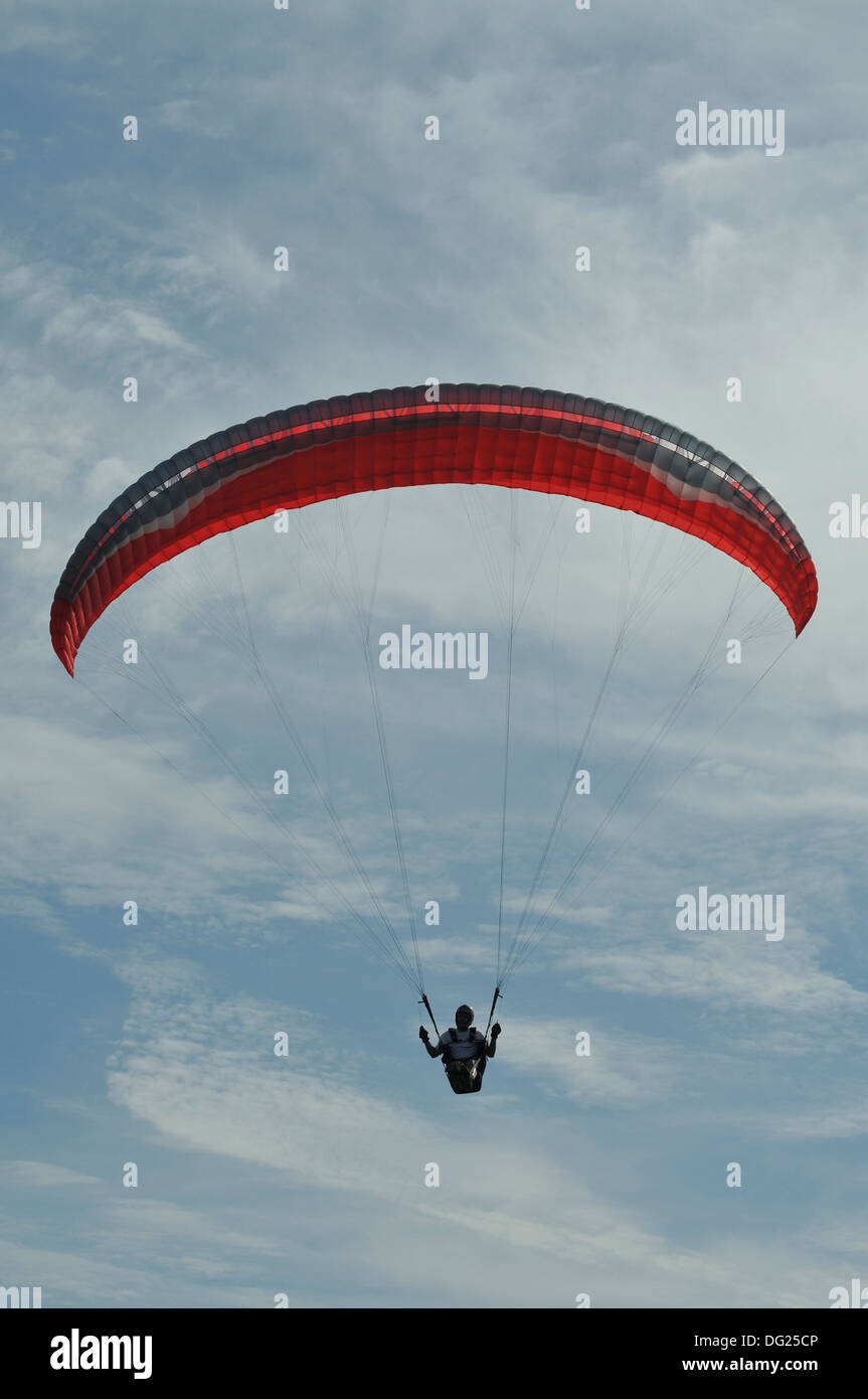 Pilot with red paraglide wing enjoys paragliding Stock Photo - Alamy