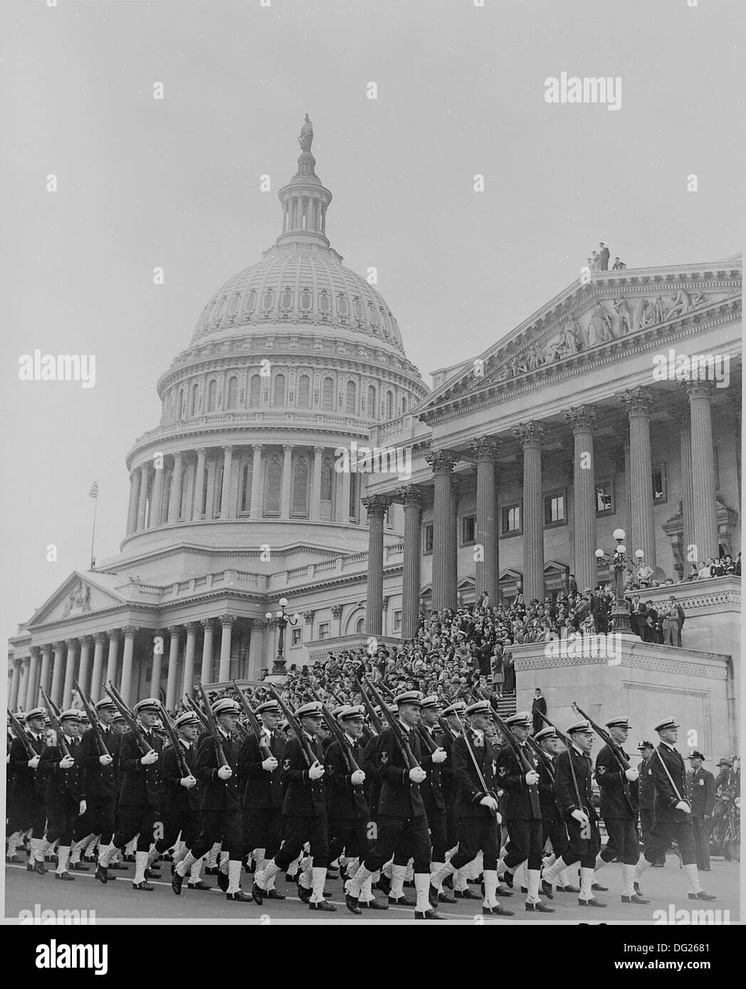 This historic photograph shows military troops marching past the U.S ...