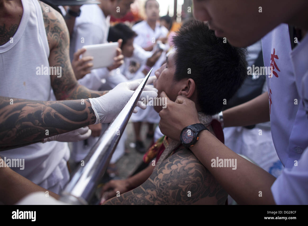 Phuket, Thailand. 12th Oct, 2013. A devotees has his face pierced with ...