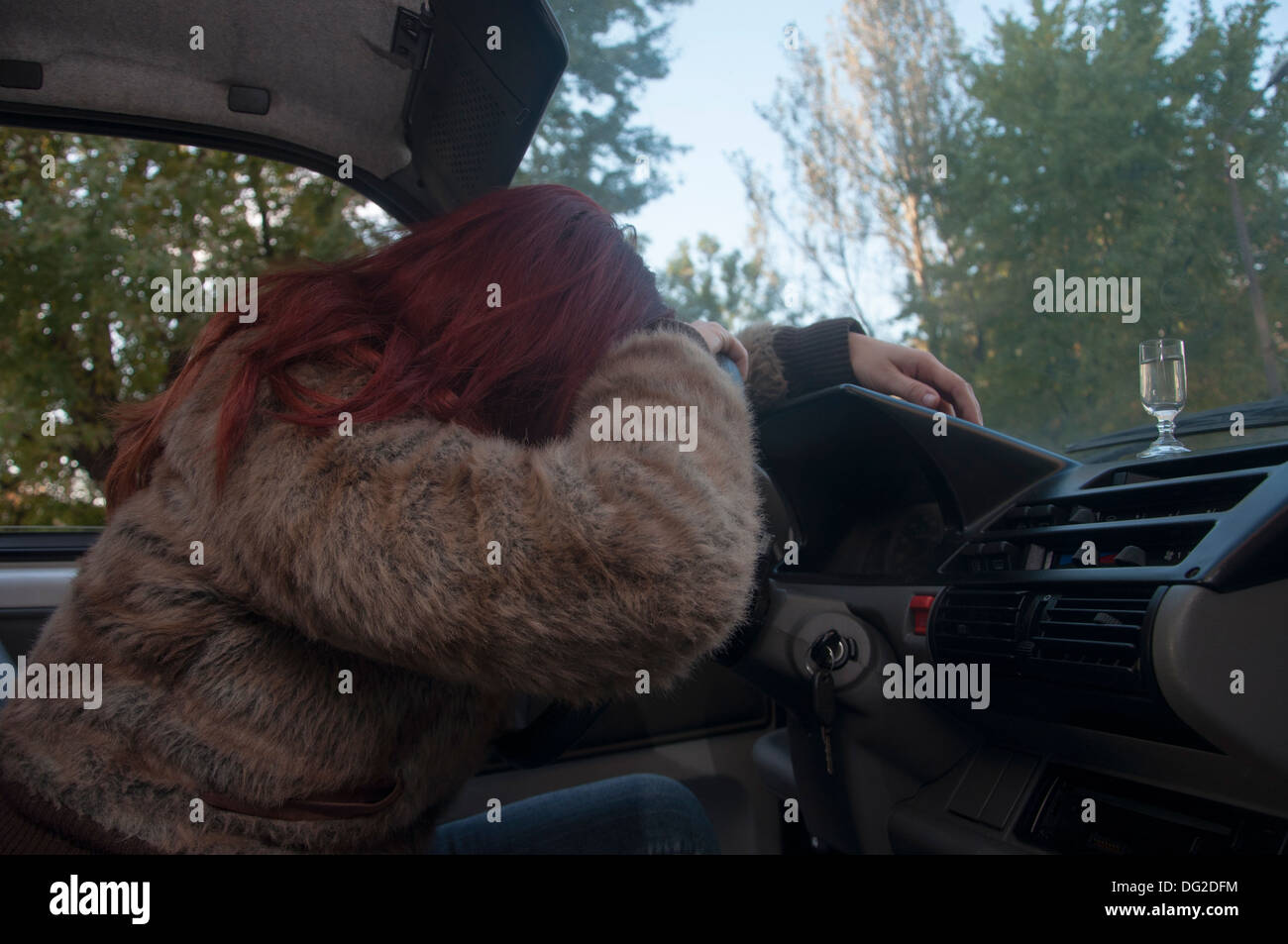 Drunk woman driving car with vodka in hand Stock Photo - Alamy