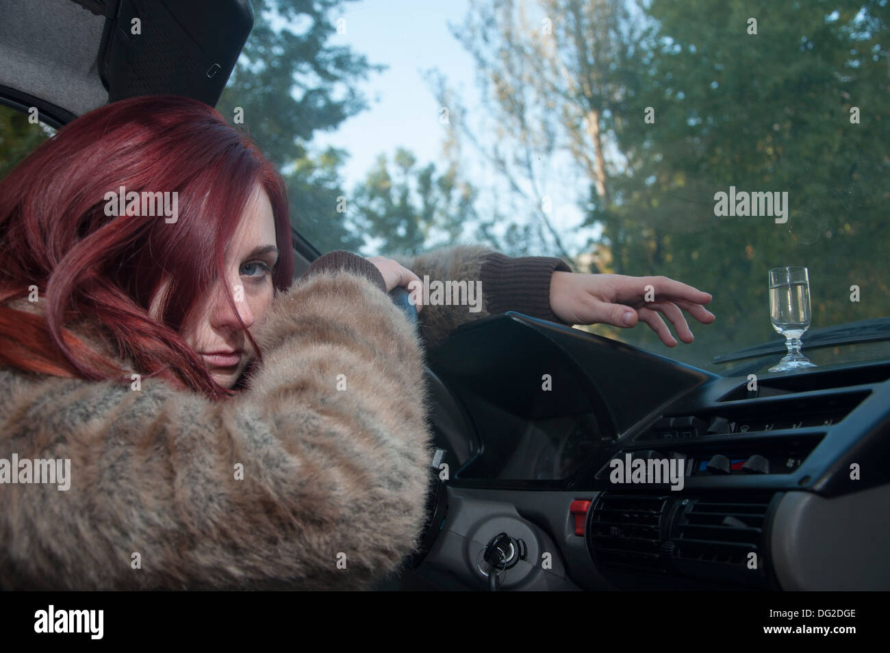 Drunk woman driving car with vodka in hand Stock Photo - Alamy