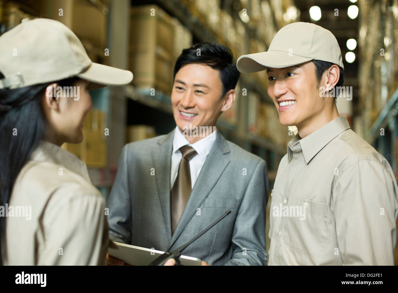 Logistics team in discussion in warehouse Stock Photo - Alamy