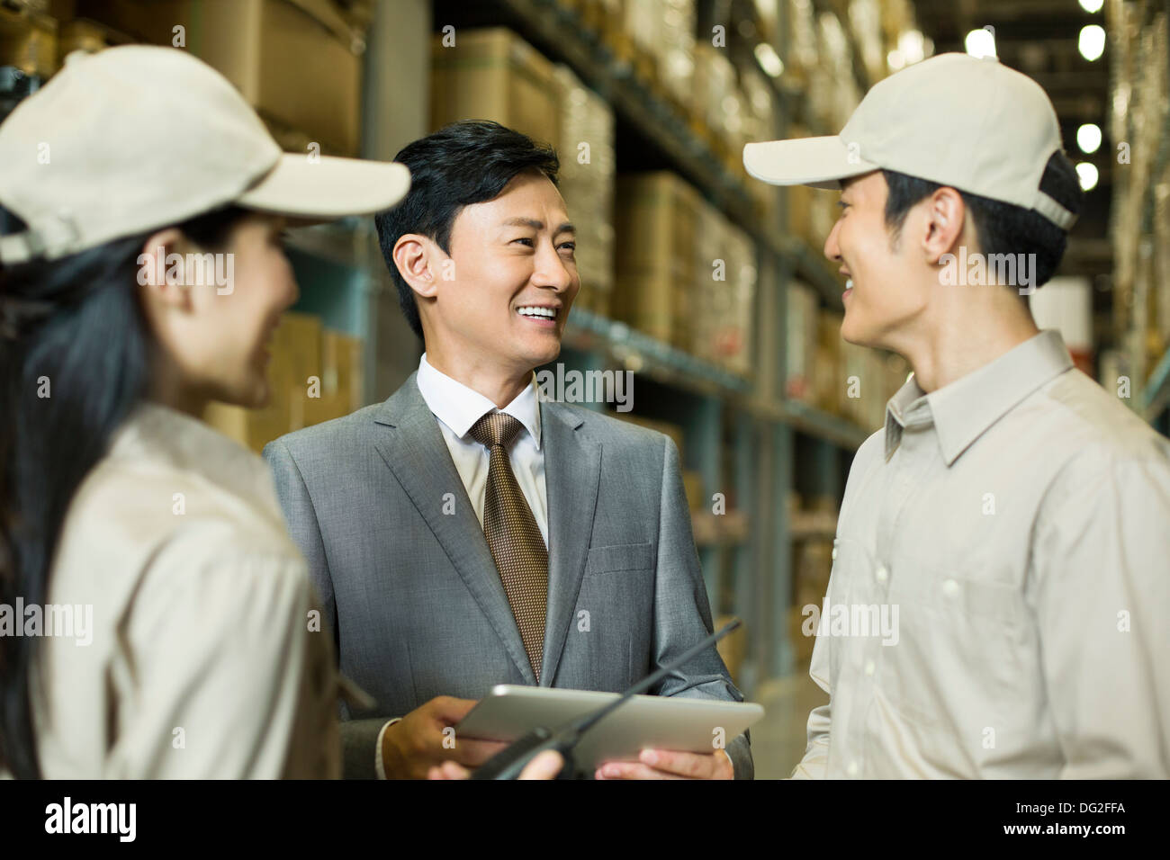 Logistics team in discussion in warehouse Stock Photo - Alamy