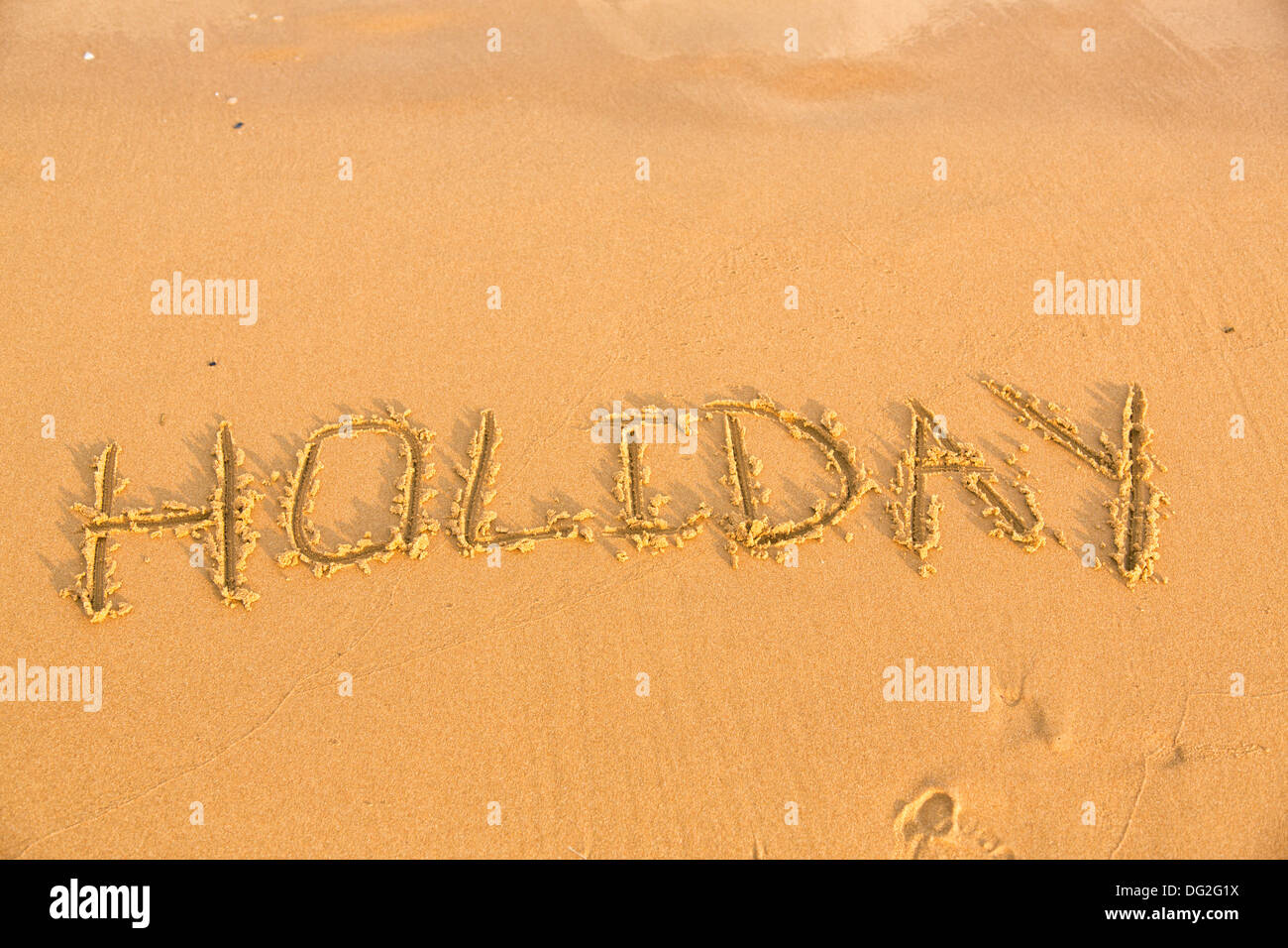 Word holiday on the yellow sandy beach, text Stock Photo - Alamy