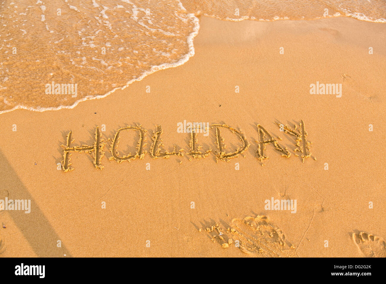 Word holiday on the yellow sandy beach, text Stock Photo - Alamy