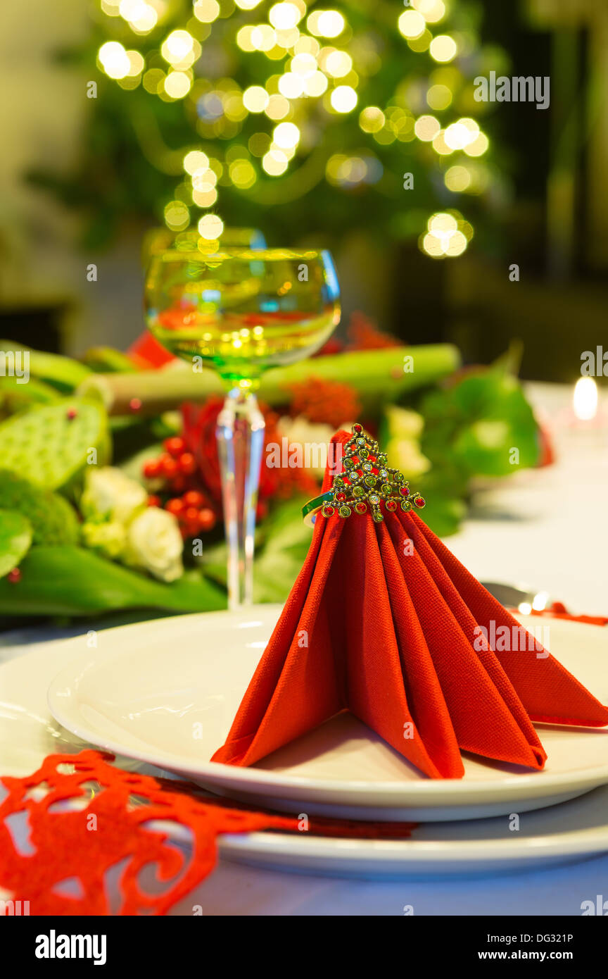 Christmas tree shining behind a decorated christmas dinner table with ...