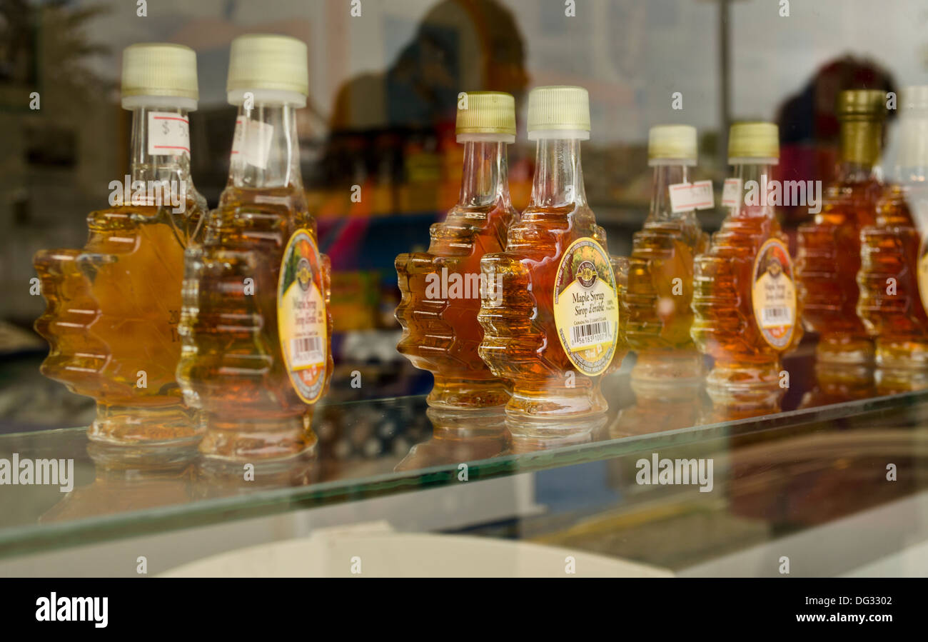 Maple leaf shaped jars of maple syrup sitting on a shelf in the window ...