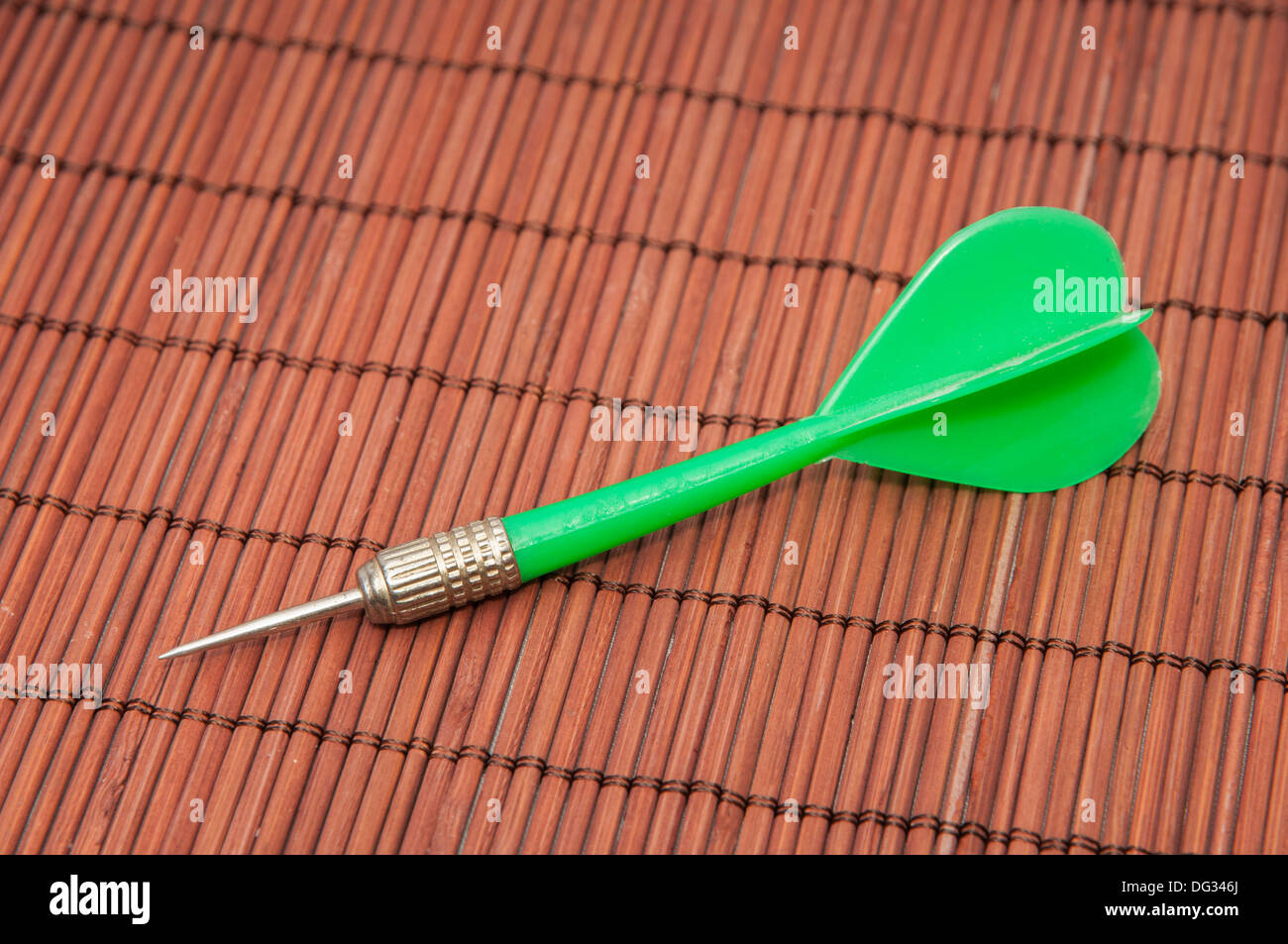 Green dart on a wooden background Stock Photo - Alamy