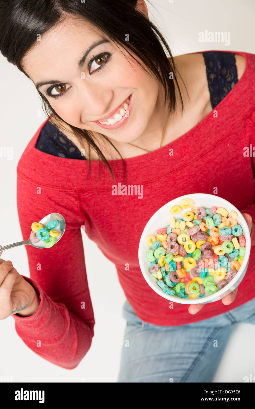 Female sits cross legged eating cereal in milk Stock Photo - Alamy