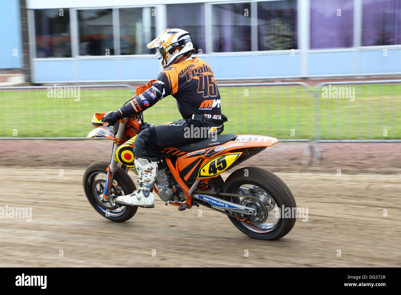 Supermoto rider accelerating on asphalt and muddy track. Focused on the ...