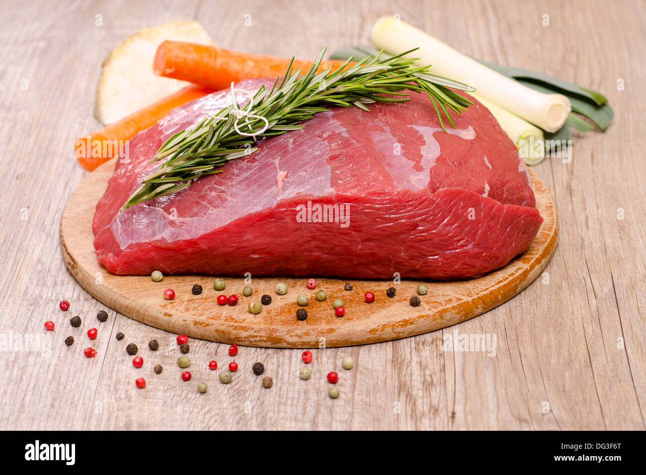 Raw roast of beef with condiments and root vegetables Stock Photo - Alamy
