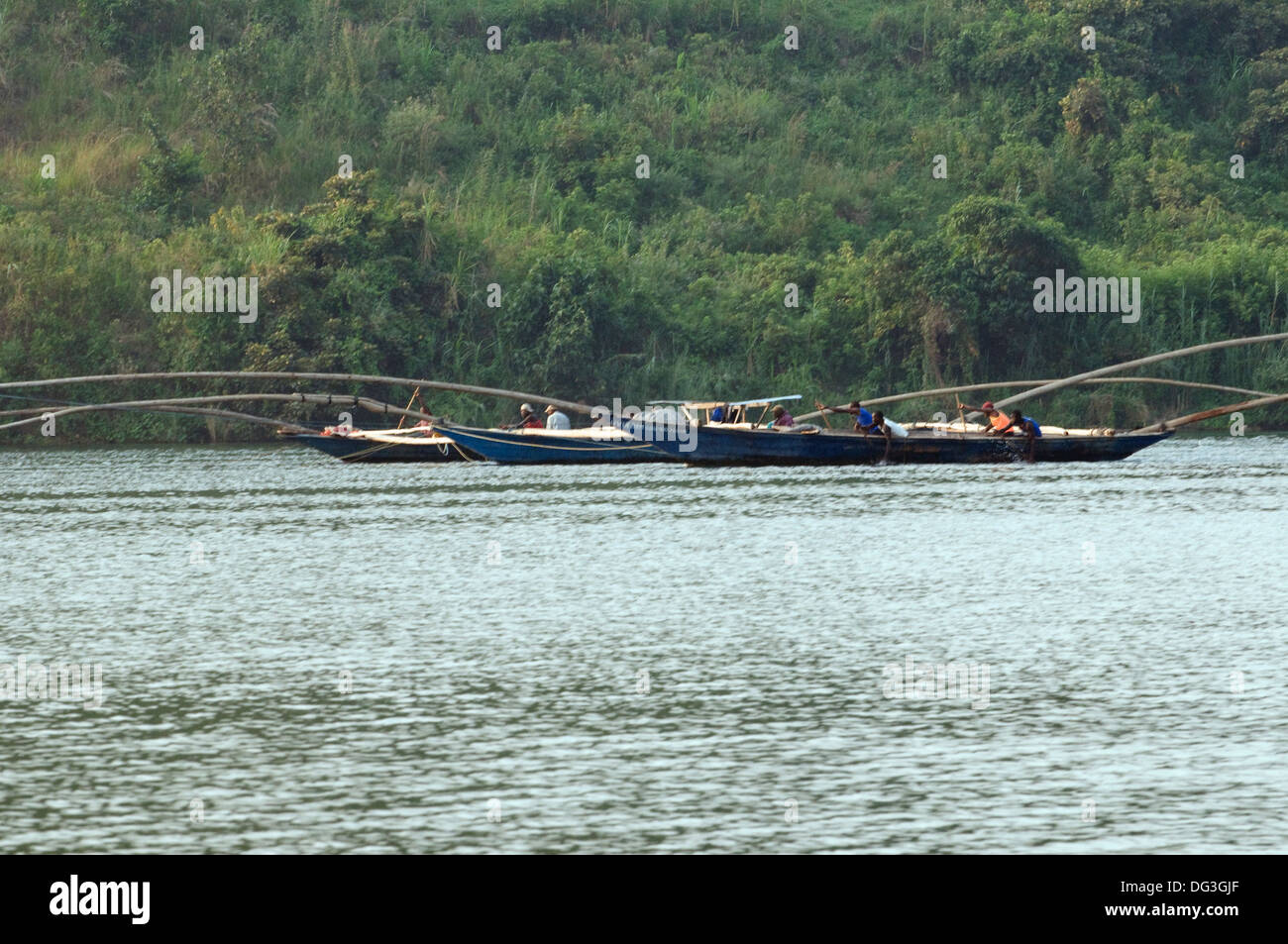 Flotilla of fishing boats working together with extended poles trawling ...