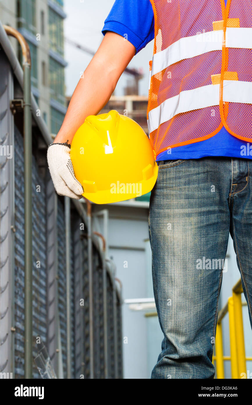 Worker on construction site with helmet or hard hat Stock Photo - Alamy