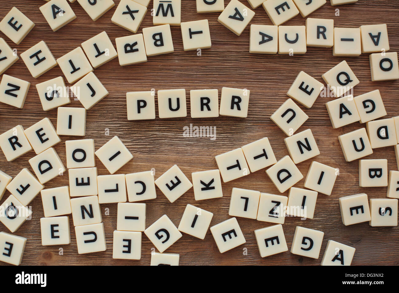 Plastic letters from a childrens' spelling game on a wooden table spell ...