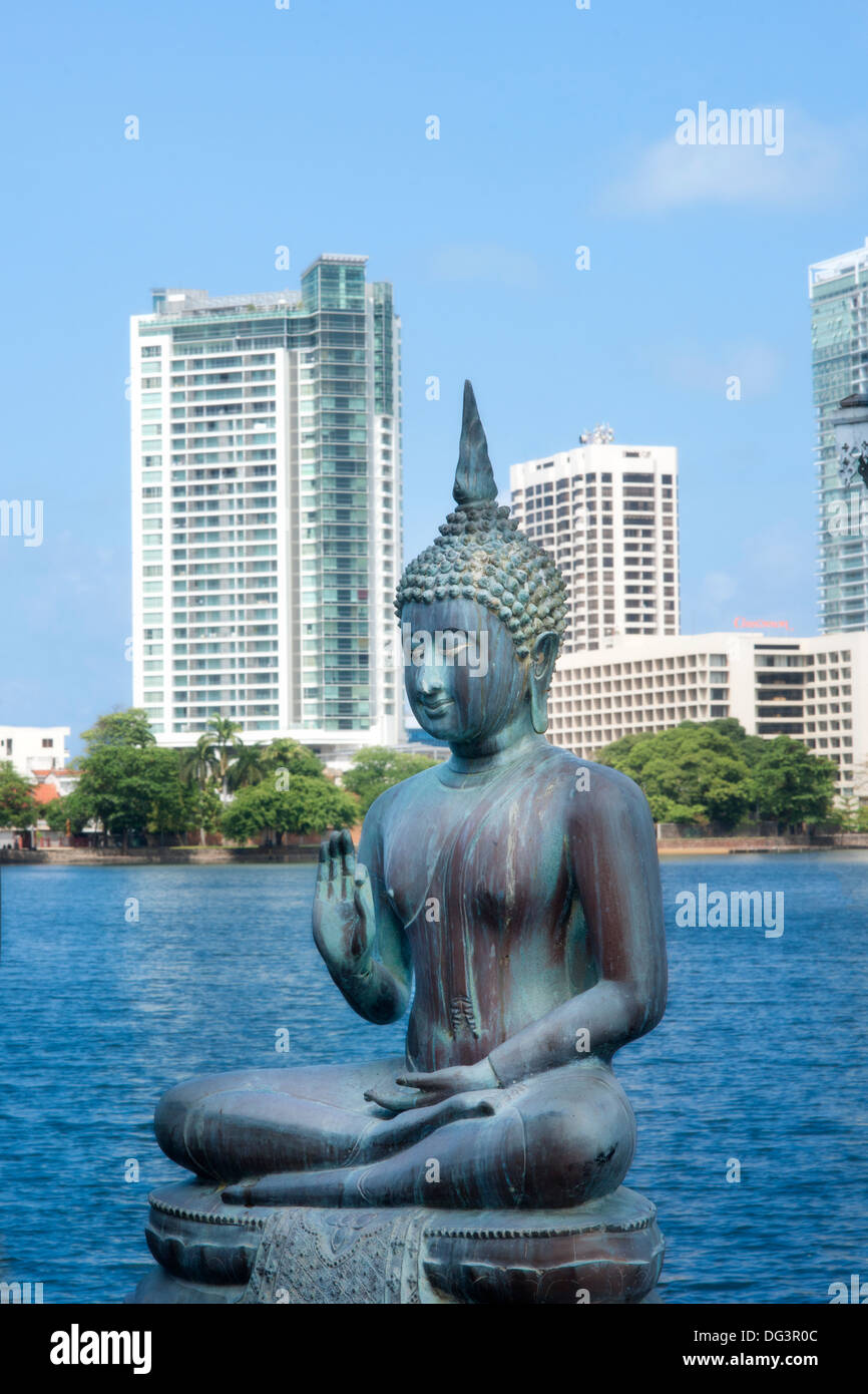 Seema Malaka Buddhist statue in front of skyscaper buildings in Colombo ...