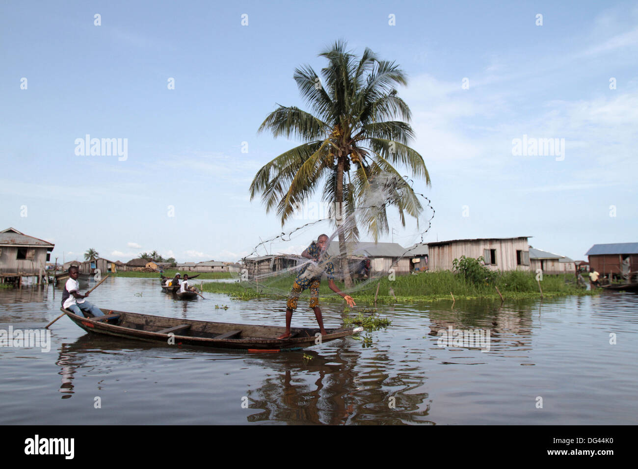 African children fishing with a net from a canoe, Lake Nokoue, Ganvie ...