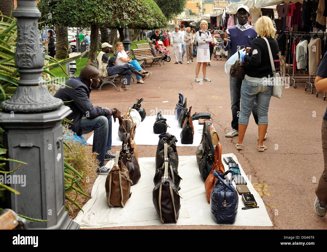 African street hawker sell handbags on the port promenade of ligurian ...