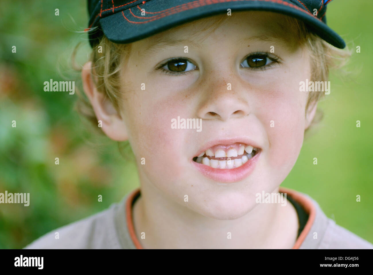 Blond, good looking child posing in a farm with a beisbol hat in ...