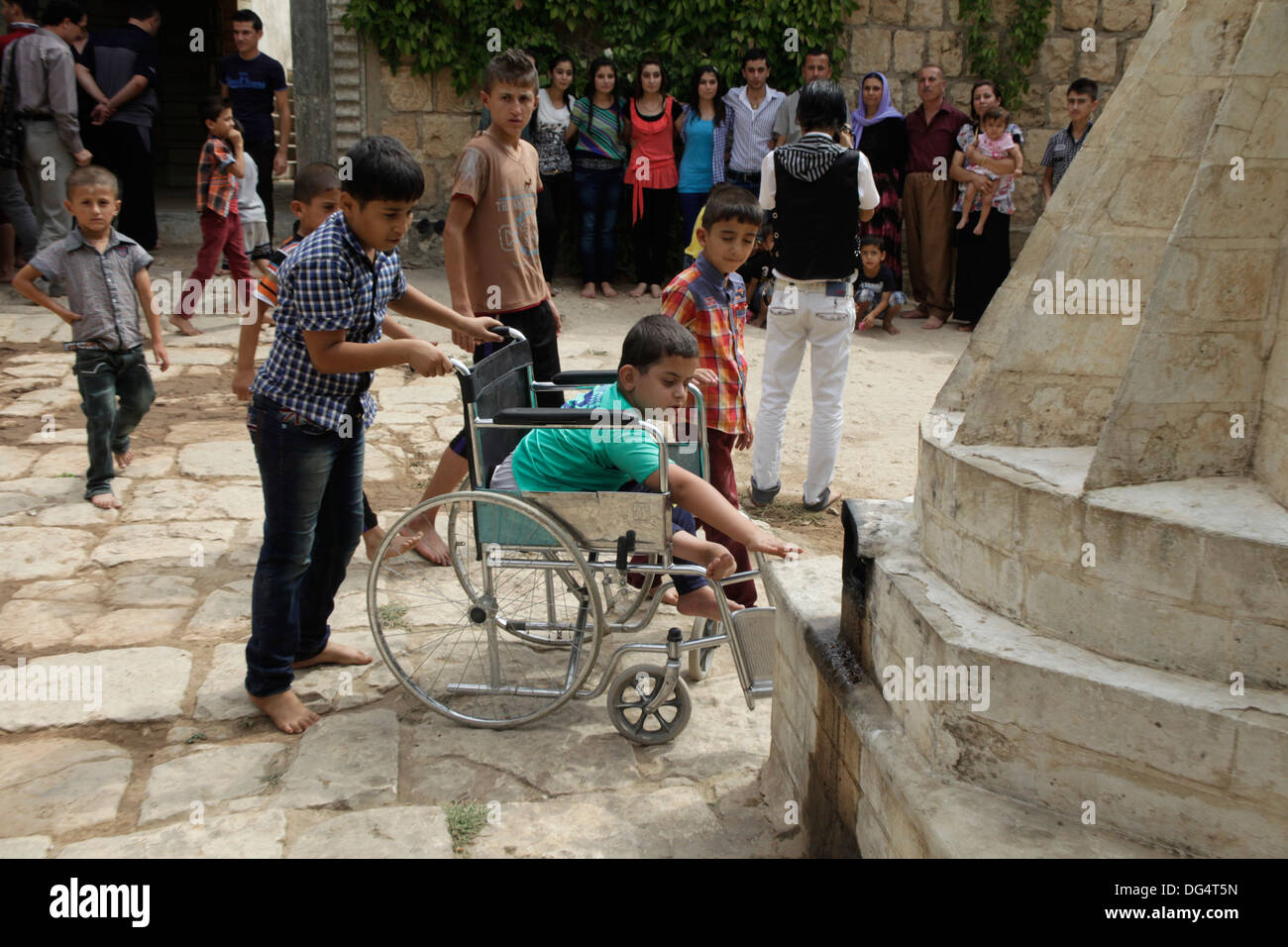 Lalish, Yazidi Holy city in North Iraq - Child in a wheelchair touch ...