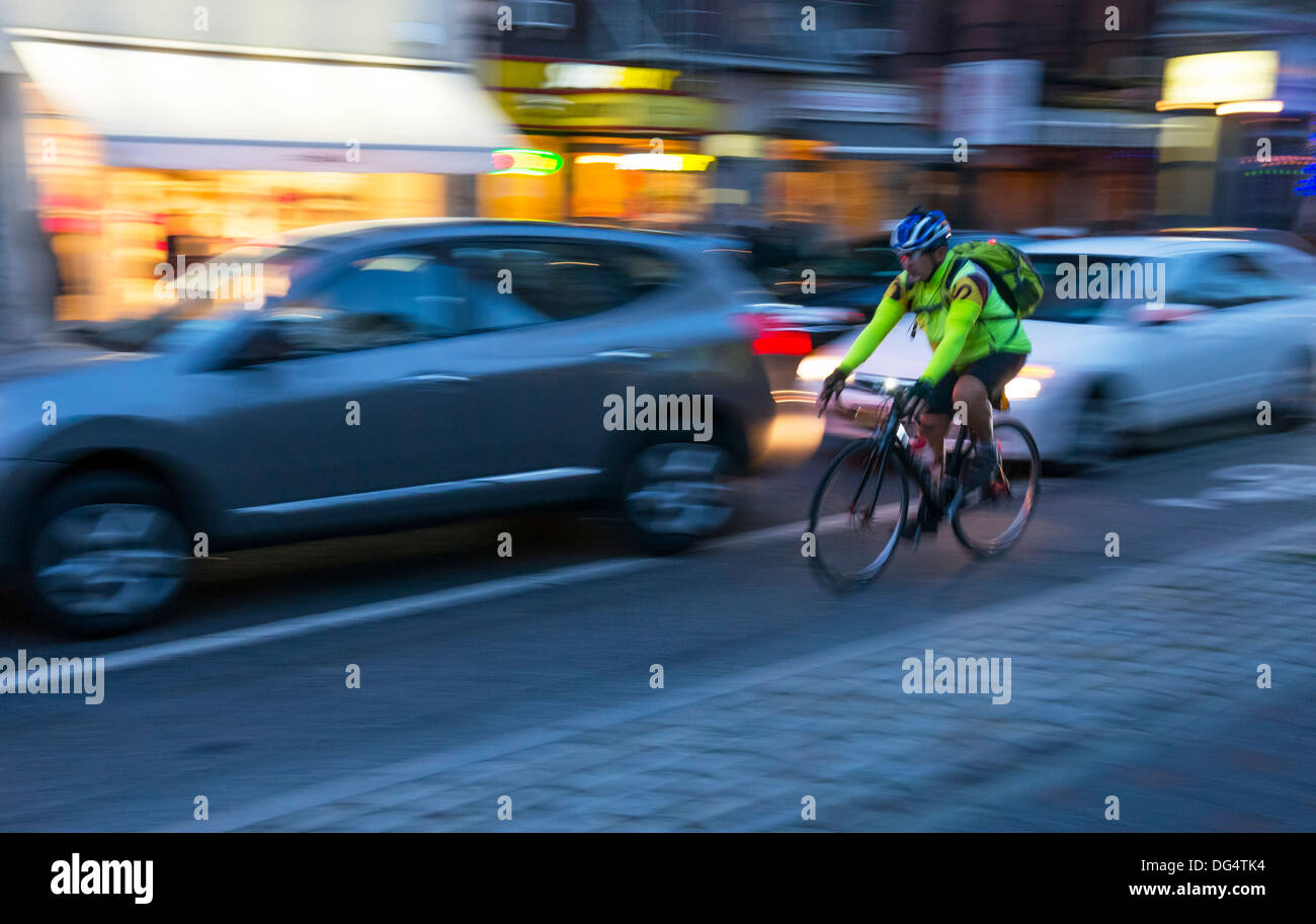 Bicycle rider at night in bike lane in New York City traffic at night ...