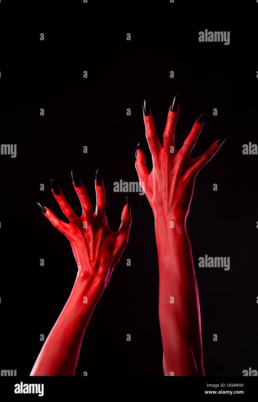 Spooky red demonic hands with black nails, Halloween theme, studio shot ...